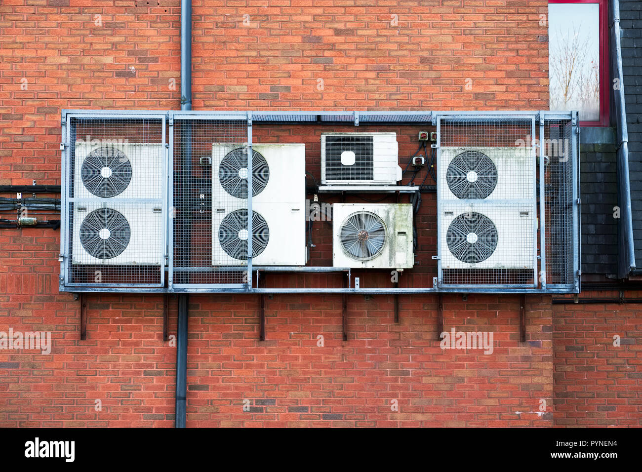 Air Conditioning condensers in cage hanging on wall Stock Photo - Alamy