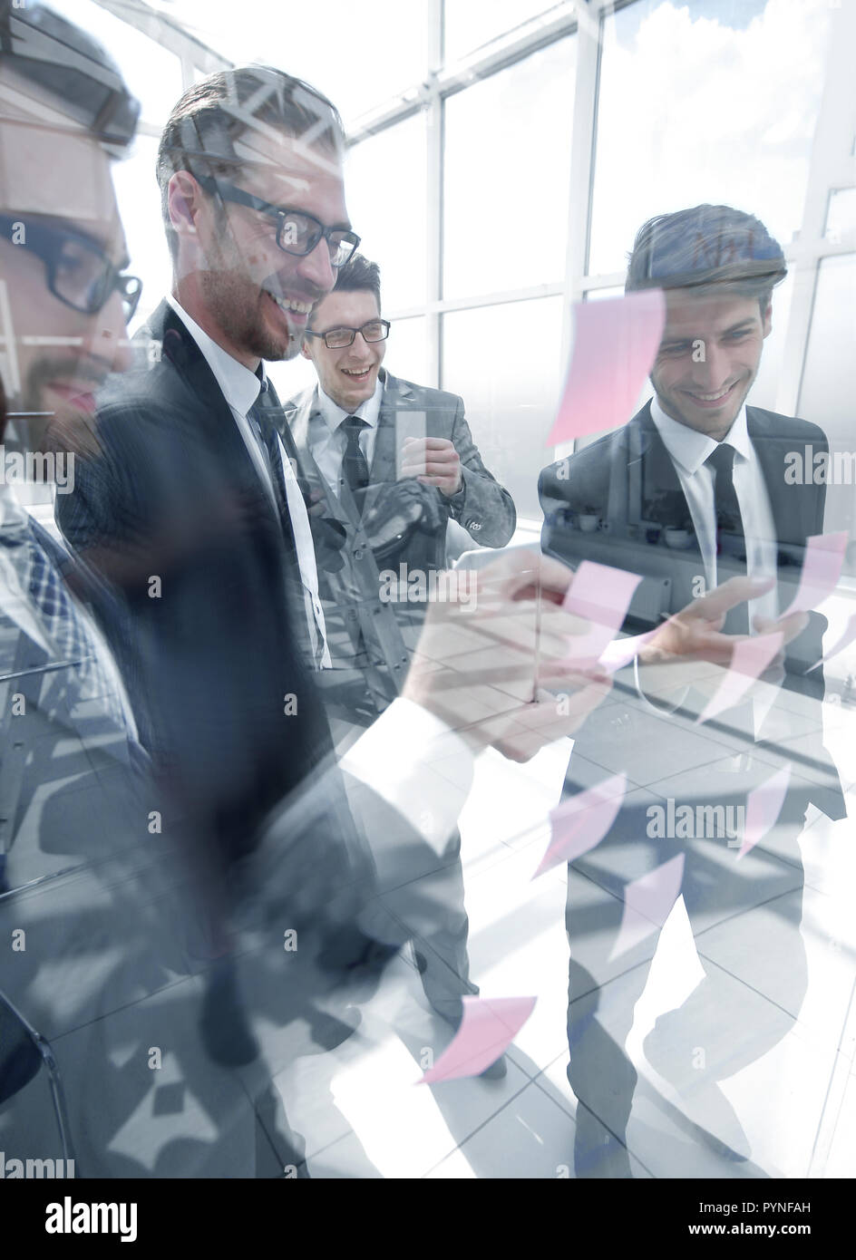 close up.successful employees reading sticky notes on glas Stock Photo ...