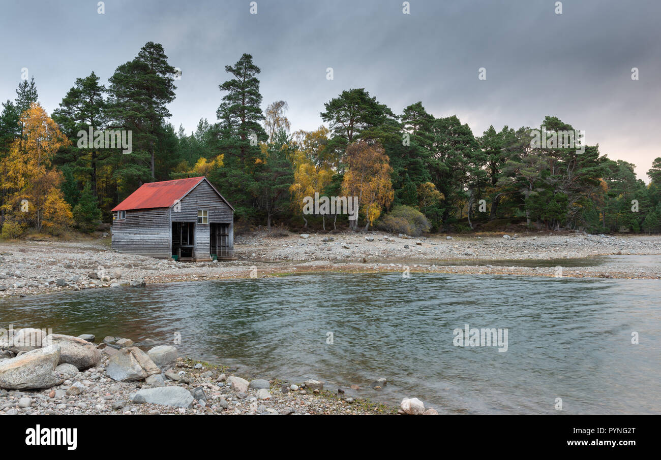 A red-roofed boathouse on the shores of Loch Vaa in the Scottish ...