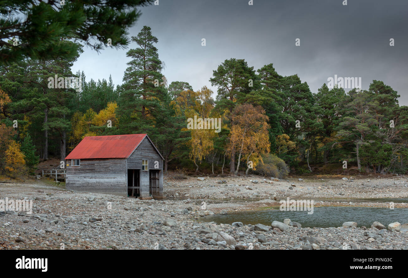 A red-roofed boathouse on the shores of Loch Vaa in the Scottish ...