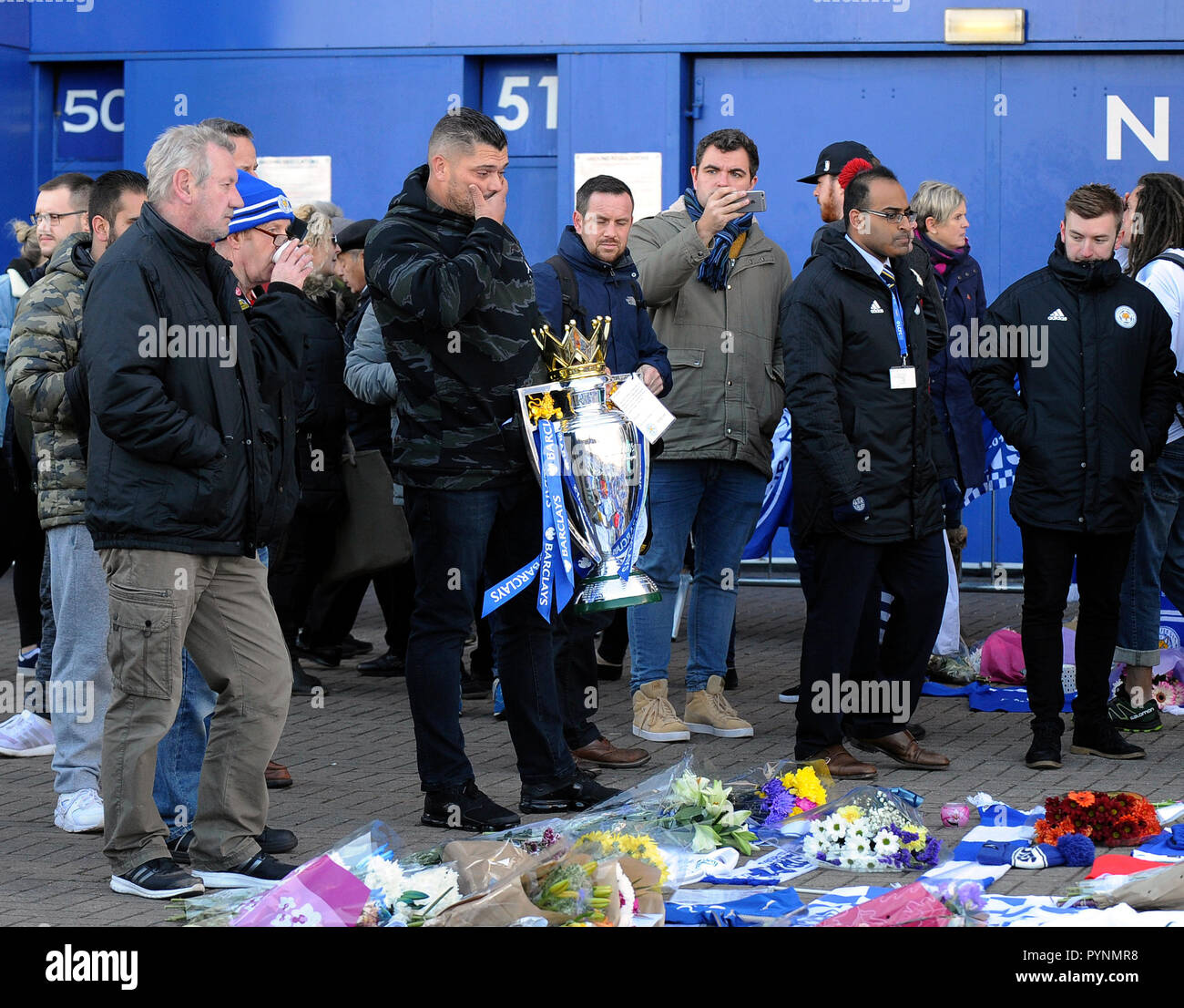 A supporter holds a replica of the Premier League trophy outside ...