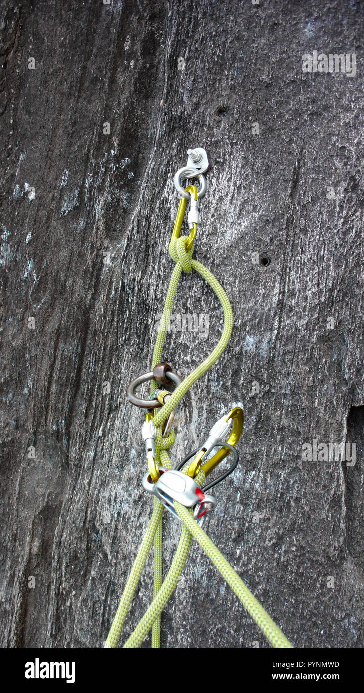 belay stance for rock climbing in black granite with bolts carabiners ...