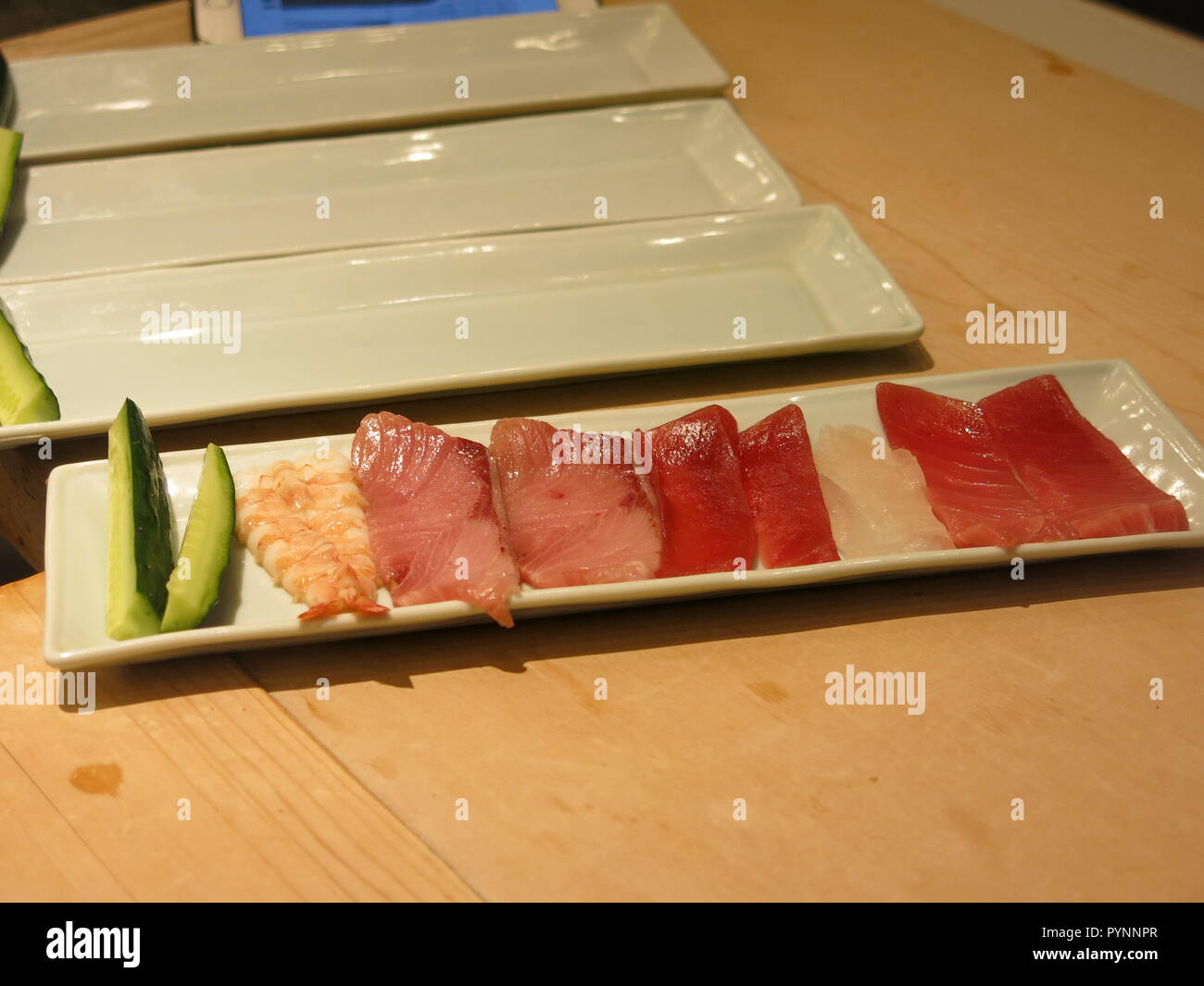 Dishes of fresh fish are lined up on the kitchen counter in preparation ...