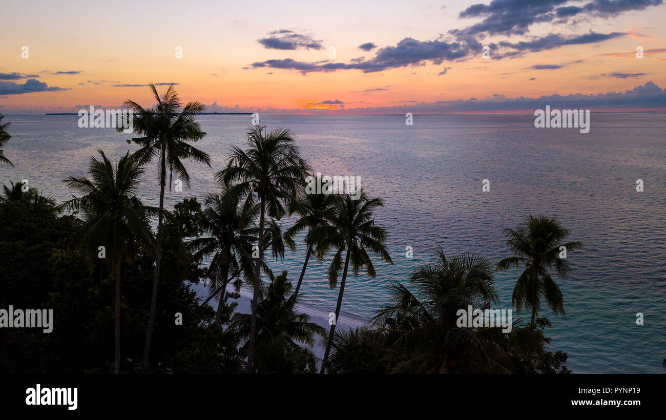 Aerial shot of sunset over the Ngurbloat equatorial beach in the Kei ...