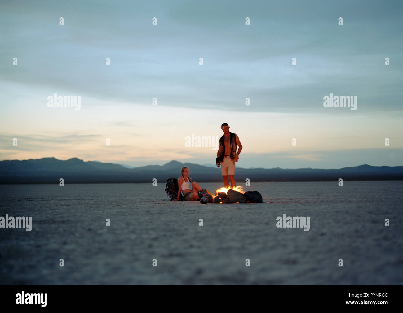 Adventurous young couple around a campfire in a remote desert Stock ...