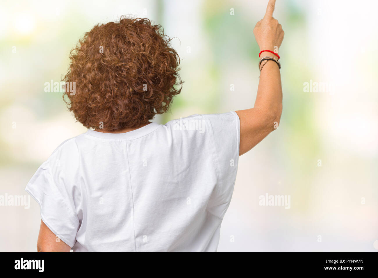 Beautiful middle ager senior woman wearing white t-shirt over isolated ...