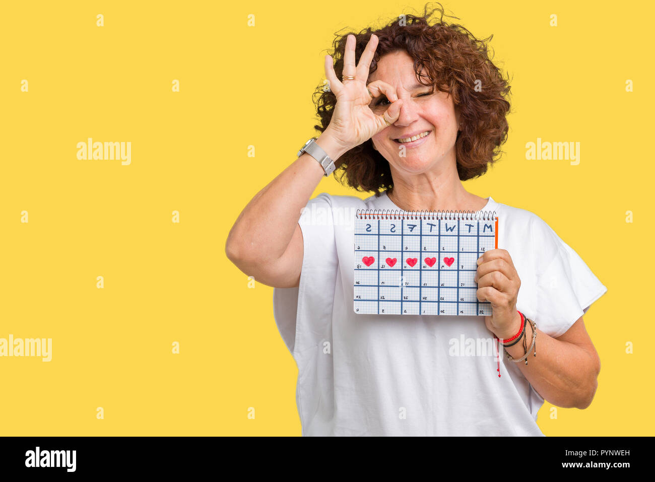 Middle ager senior woman holding menstruation calendar over isolated ...