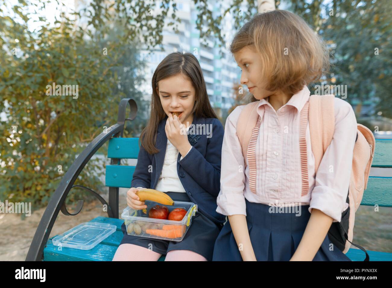 Outdoor portrait of elementary school students with lunch boxes ...