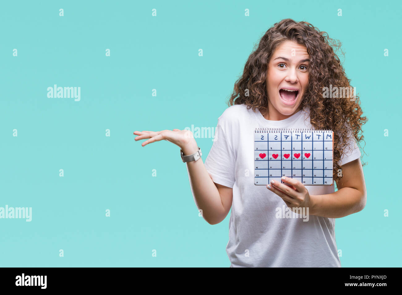 Young brunette girl holding menstruation calendar over isolated ...