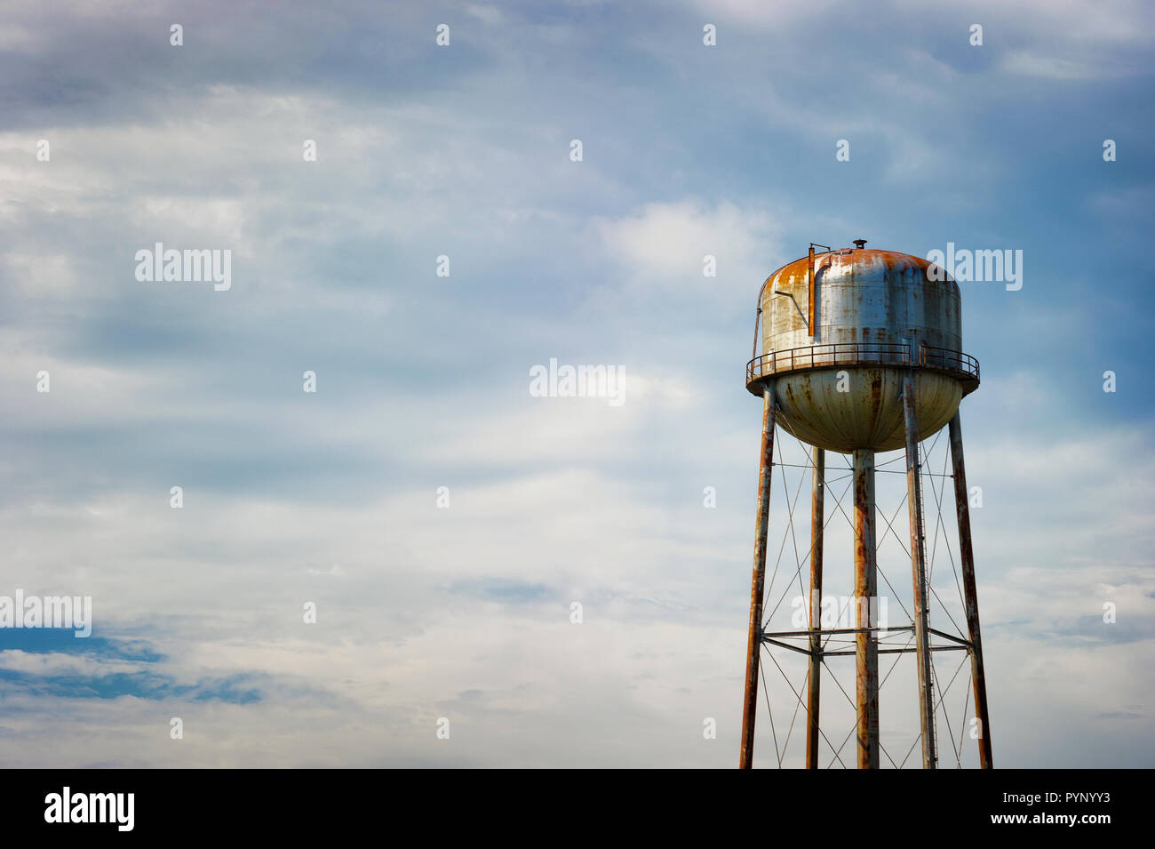 Copy space in a minimalist photography of a rusty water tower under ...