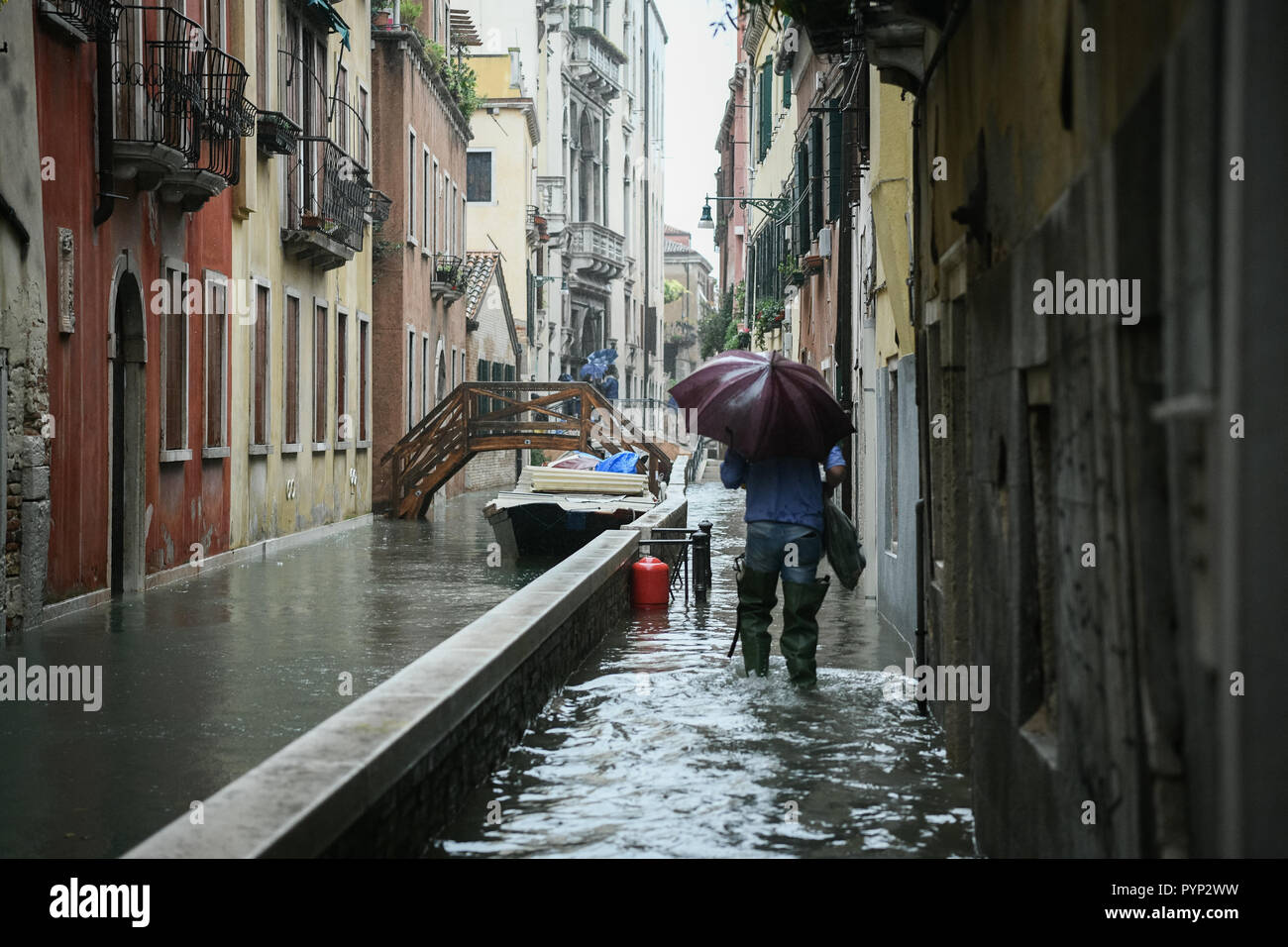 Venice, Italy. 29th October, 2018. A man with umbrella and wellies ...
