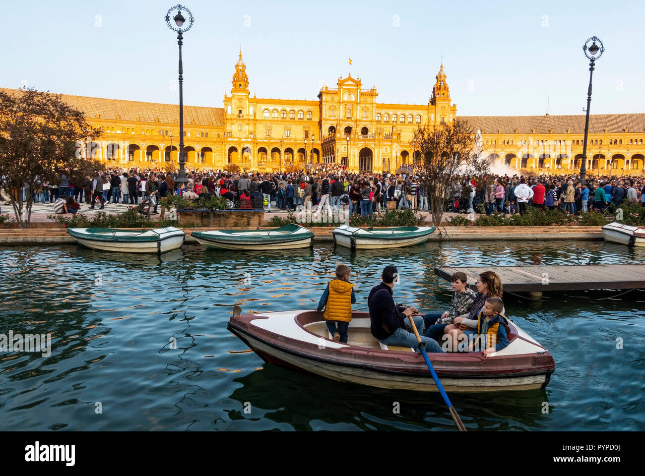 A family in a rented rowboat on the goldfish pond in Plaza de España in ...