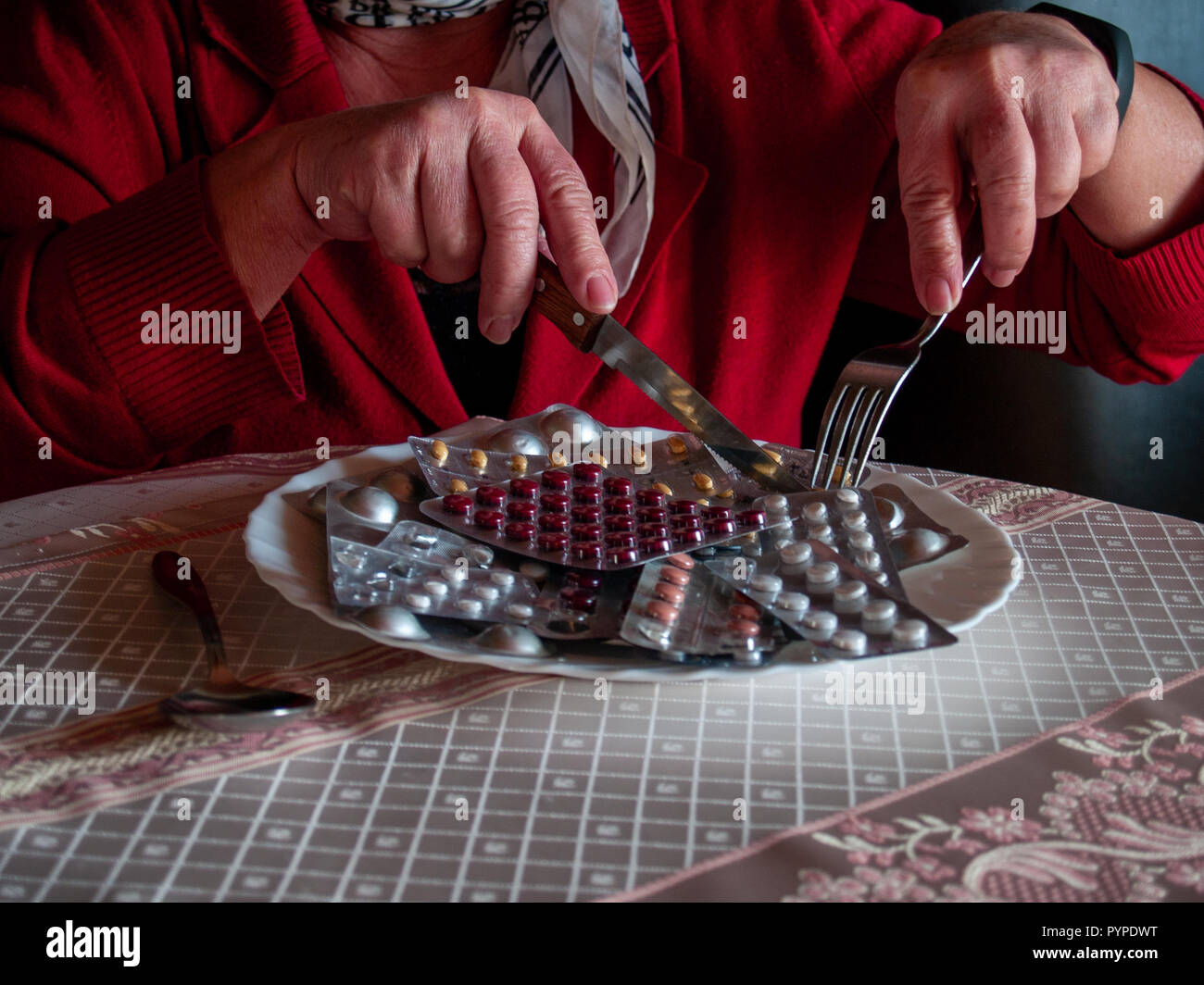Concept of medicine and health care. A person cutting several tablets ...