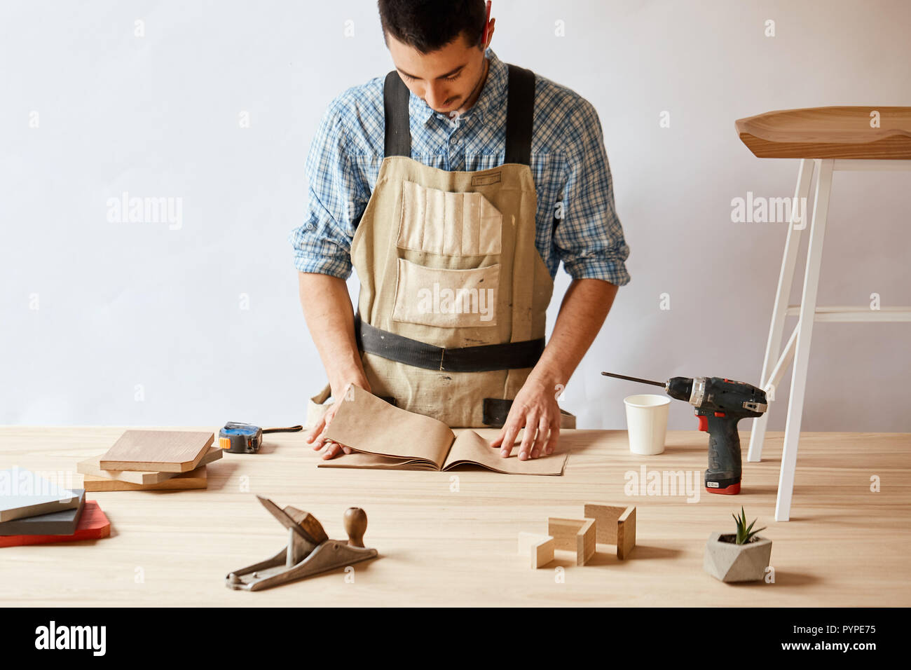 Closeup view of a carpenter using a red pencil to draw a line on a ...