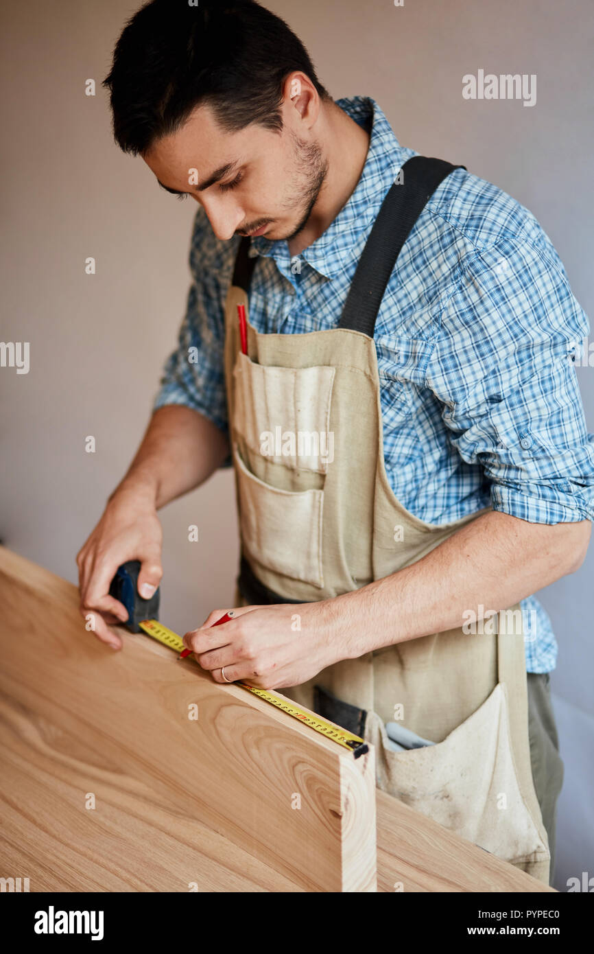 hand of a carpenter taking measurement of a wooden plank Stock Photo ...