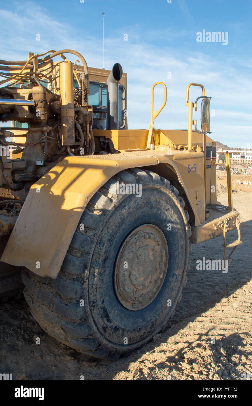 The large cab area and giant tires of a large construction grader Stock ...
