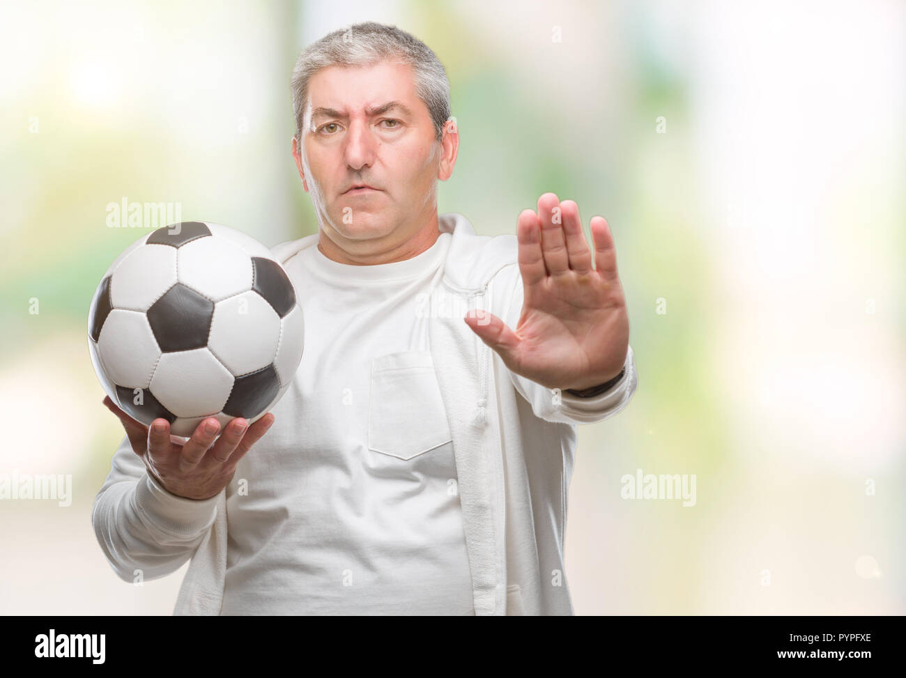 Handsome senior man holding soccer football ball over isolated ...
