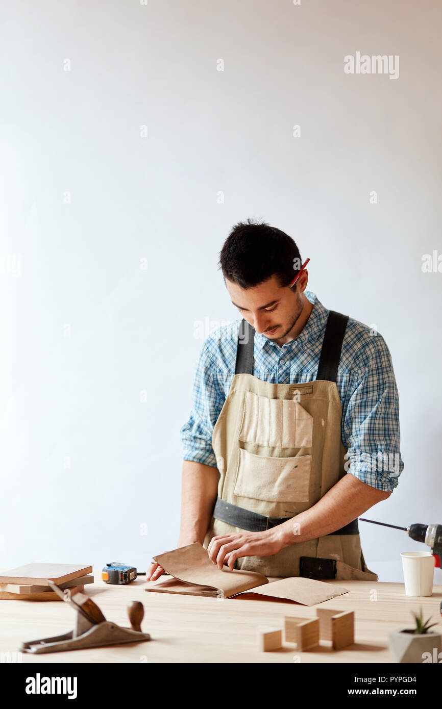 Closeup view of a carpenter using a red pencil to draw a line on a ...