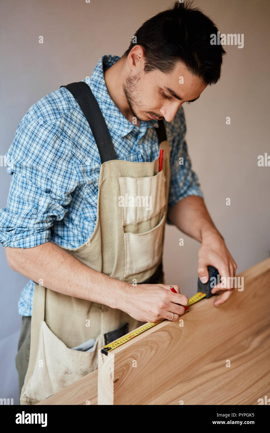 hand of a carpenter taking measurement of a wooden plank Stock Photo ...