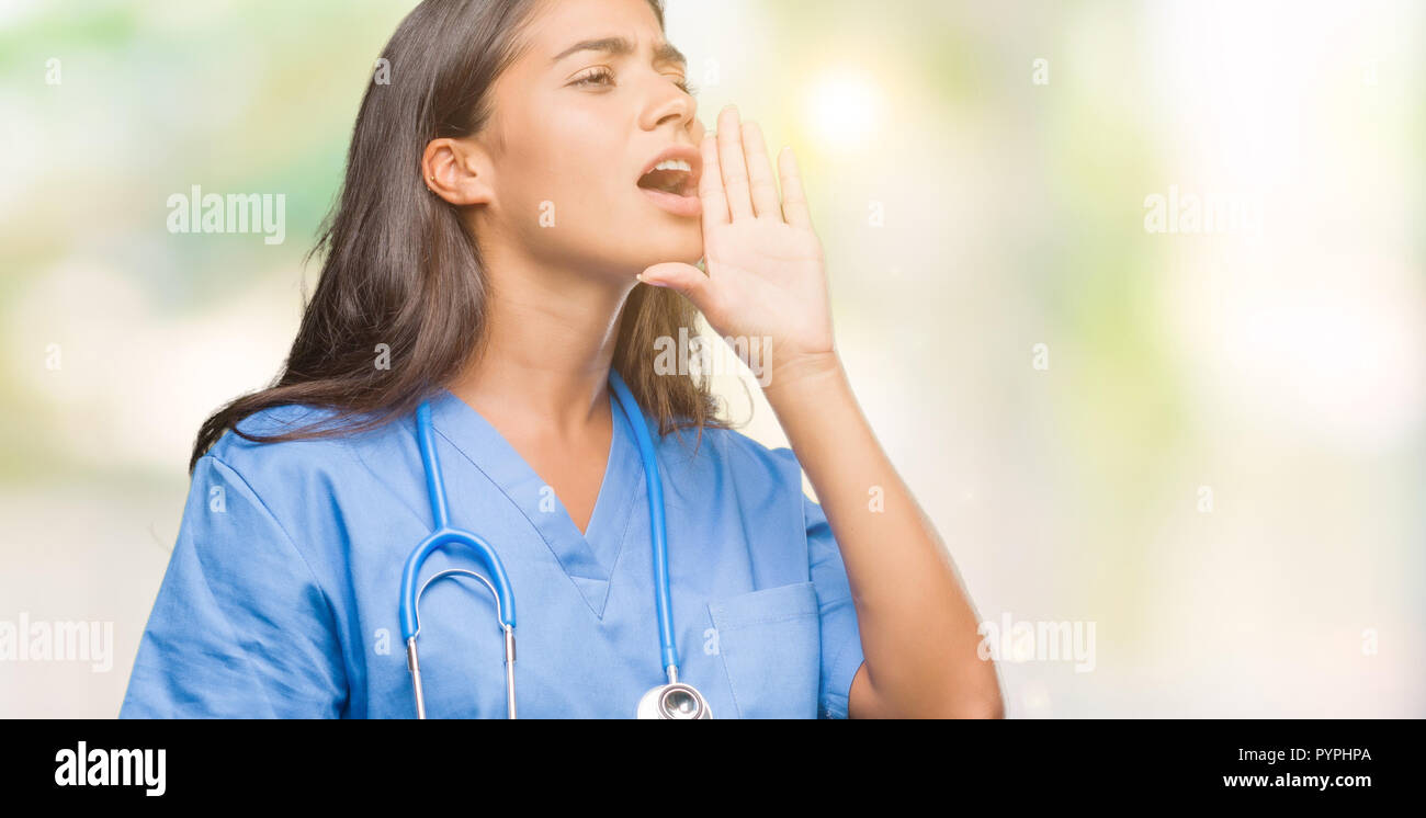 Young arab doctor surgeon woman over isolated background shouting and ...