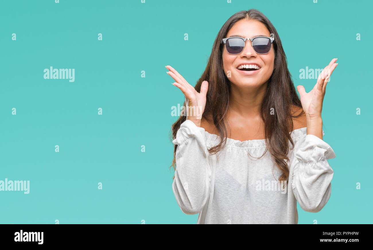 Young beautiful arab woman wearing sunglasses over isolated background ...