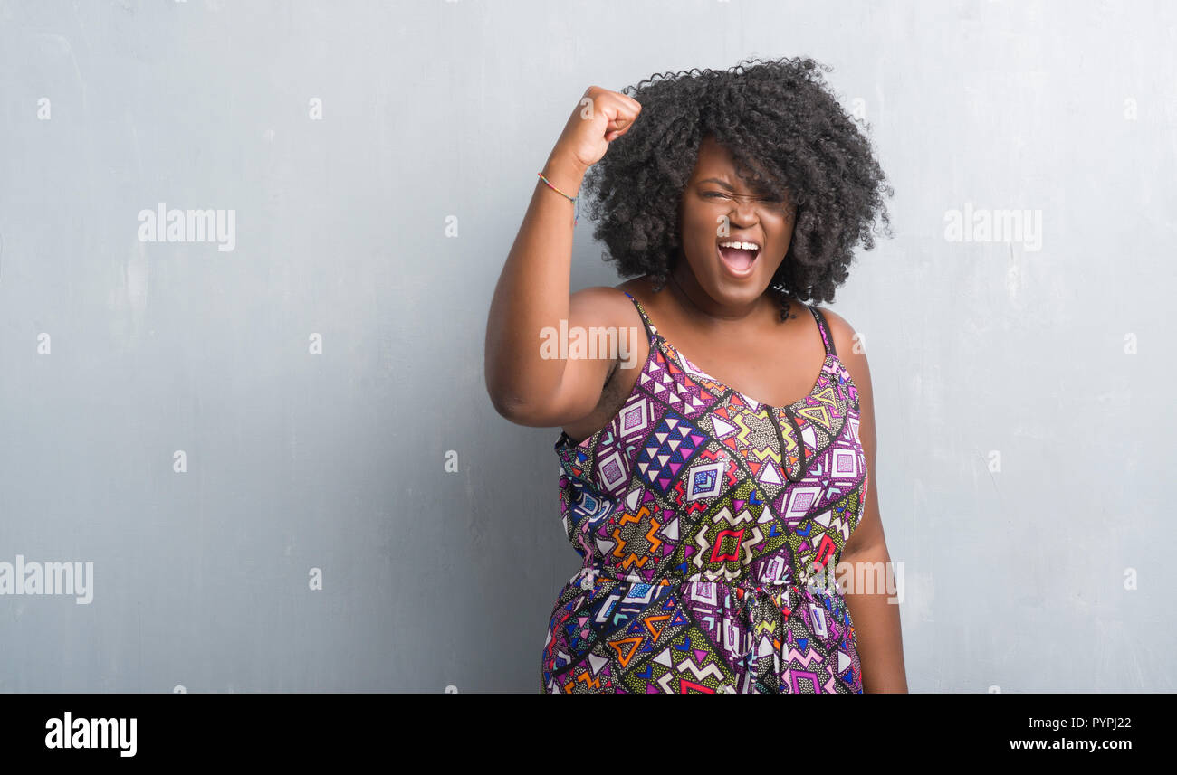 Young african american woman over grey grunge wall wearing colorful ...