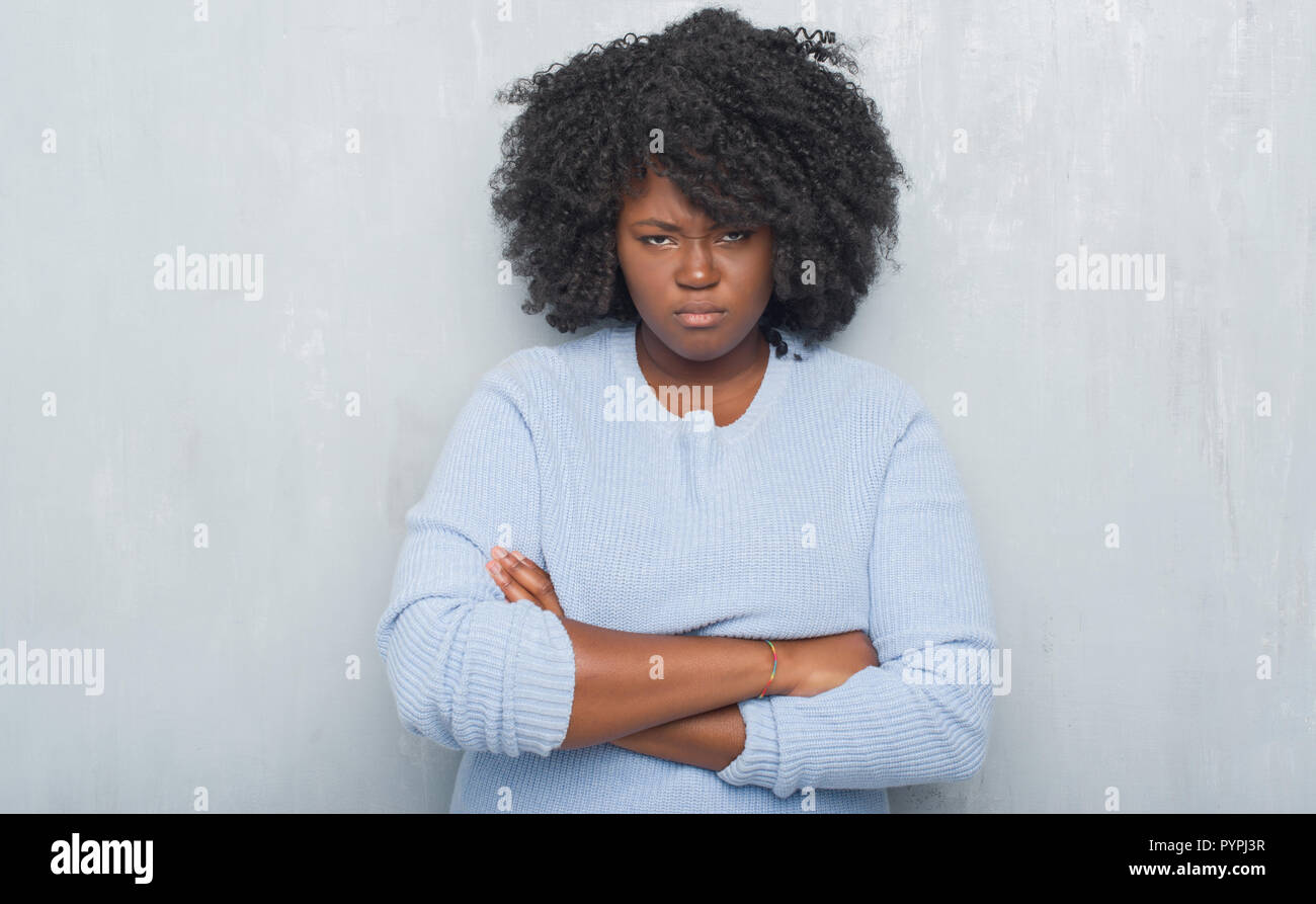 Young african american woman over grey grunge wall wearing winter ...