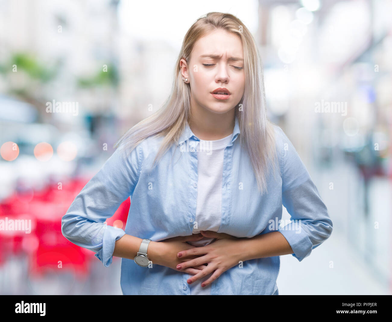 Young blonde woman over isolated background with hand on stomach ...