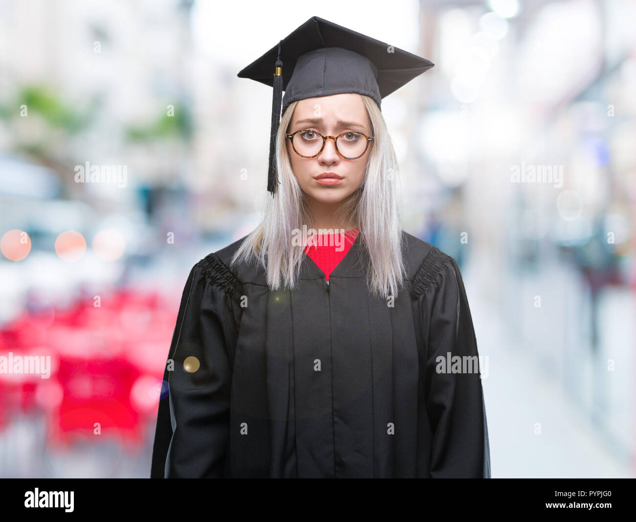 Young blonde woman wearing graduate uniform over isolated background ...
