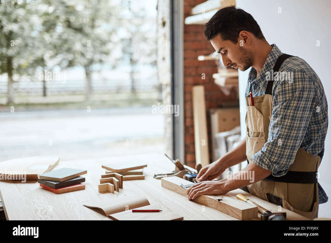 hand of a carpenter taking measurement of a wooden plank Stock Photo ...