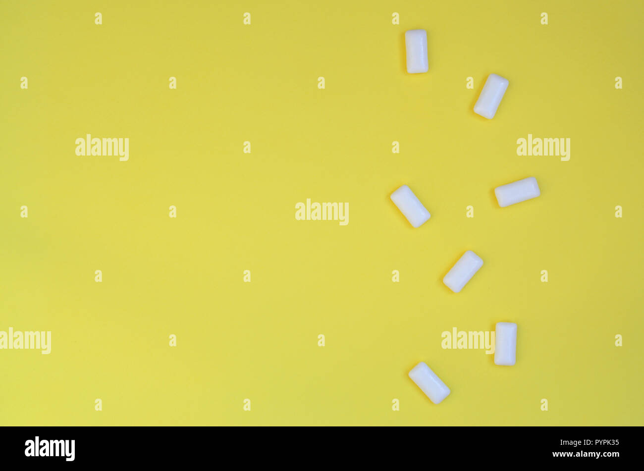 A few chewing gums lie on texture background of fashion pastel yellow ...