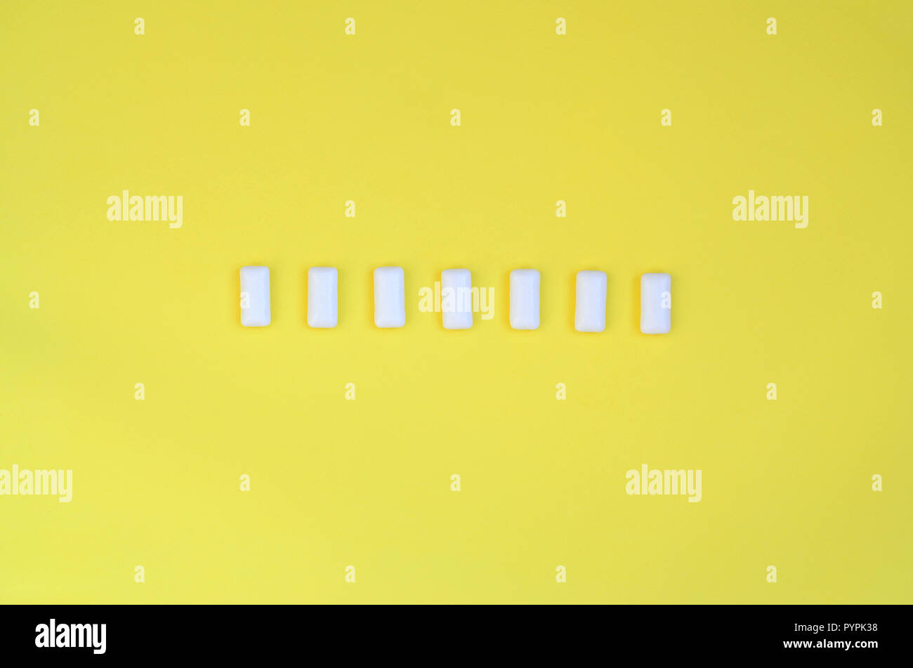 A few chewing gums lie on texture background of fashion pastel yellow ...