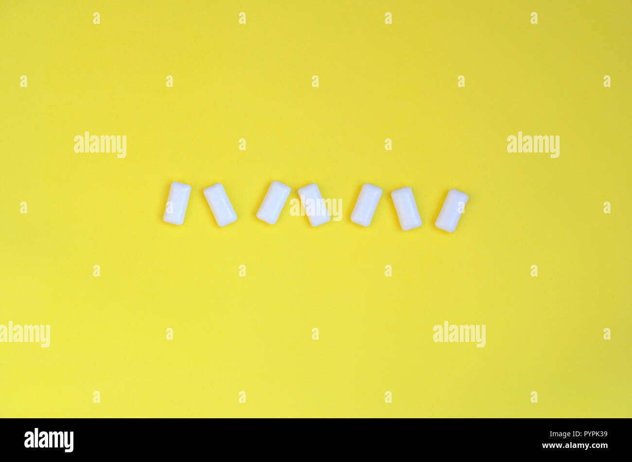 A few chewing gums lie on texture background of fashion pastel yellow ...