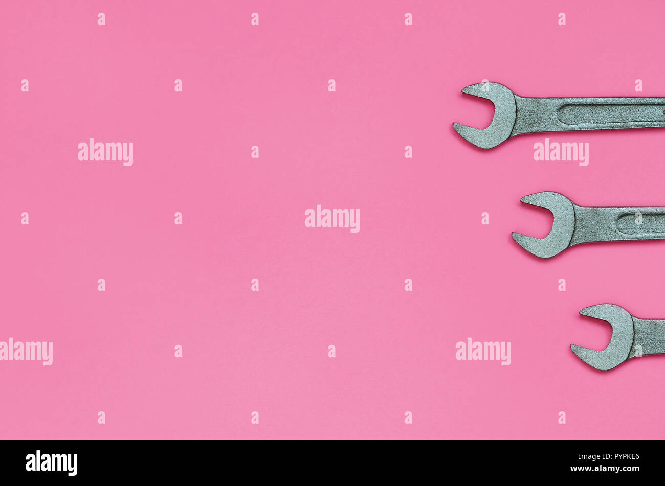 Three metallic spanners lie on texture background of fashion pastel ...