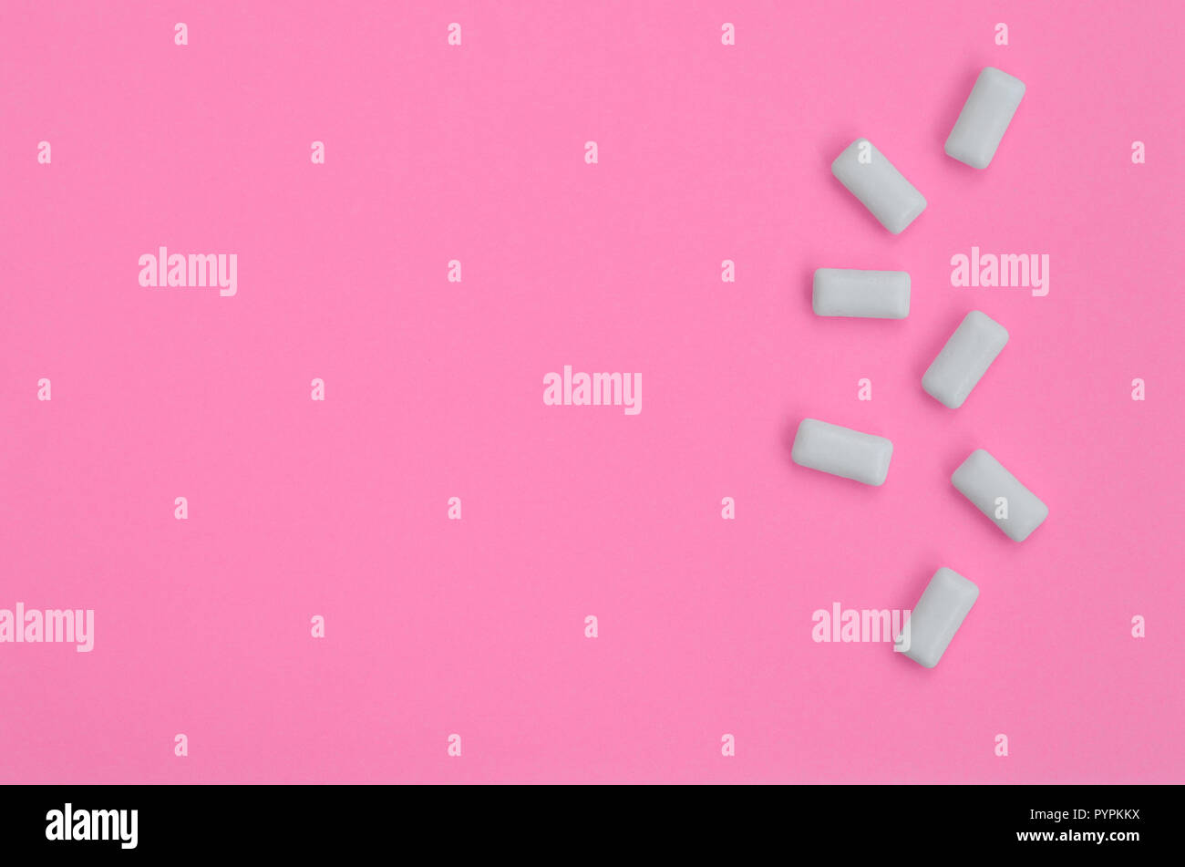A few chewing gums lie on texture background of fashion pastel pink ...