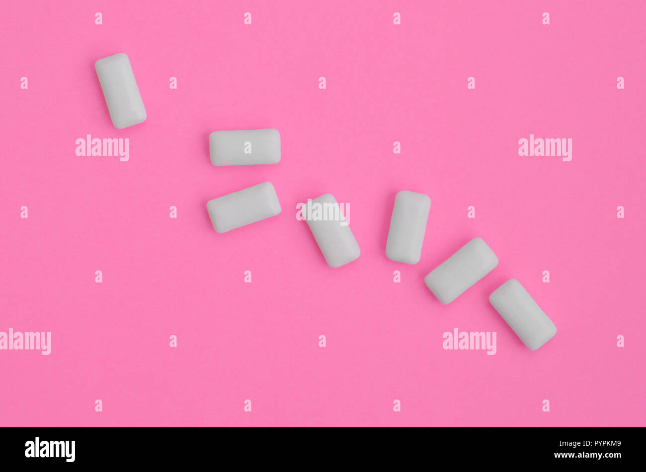A few chewing gums lie on texture background of fashion pastel pink ...