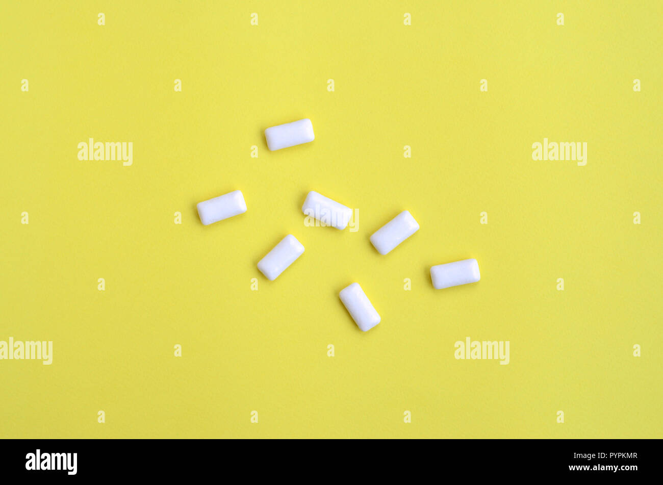 A few chewing gums lie on texture background of fashion pastel yellow ...