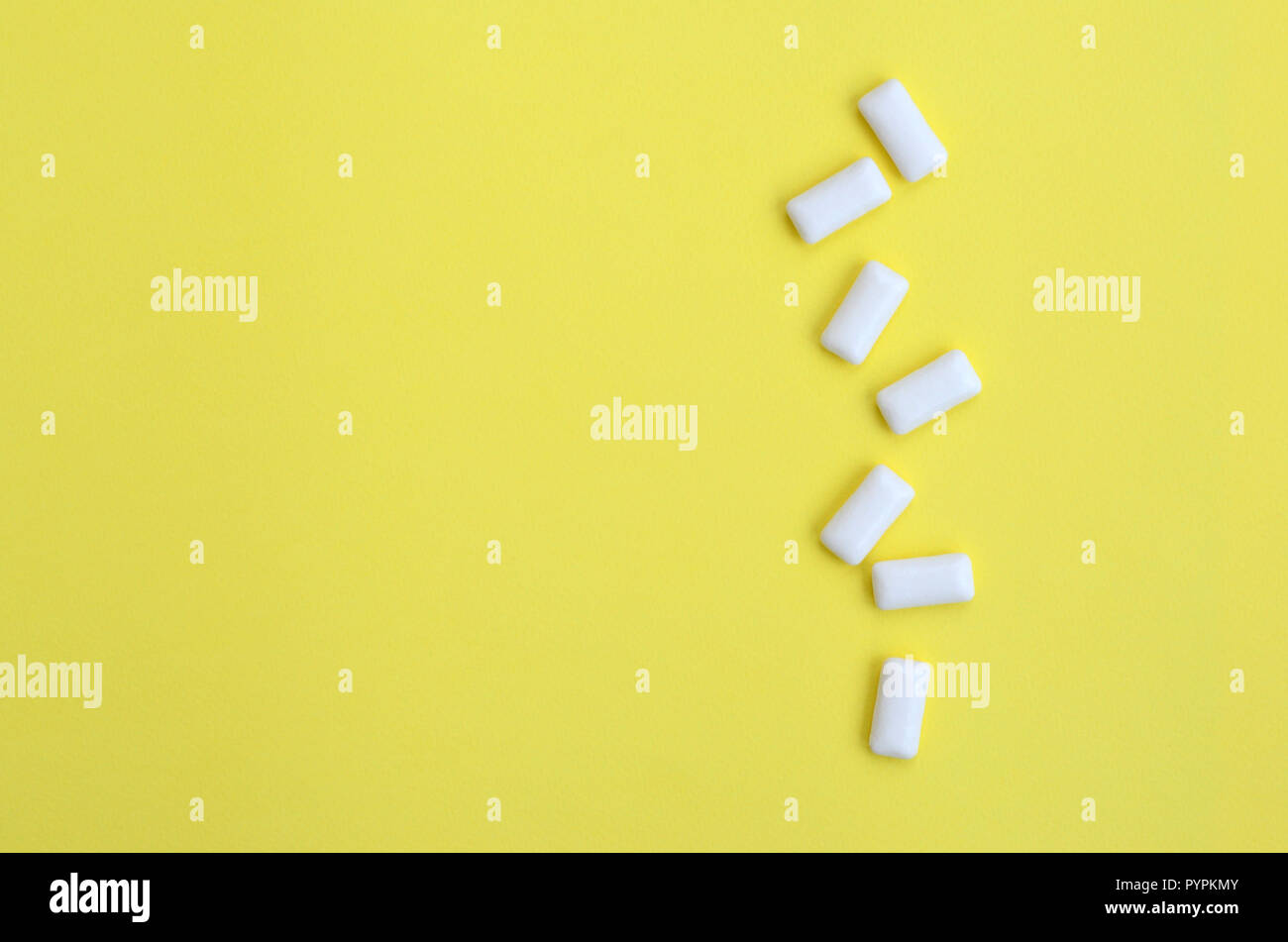 A few chewing gums lie on texture background of fashion pastel yellow ...