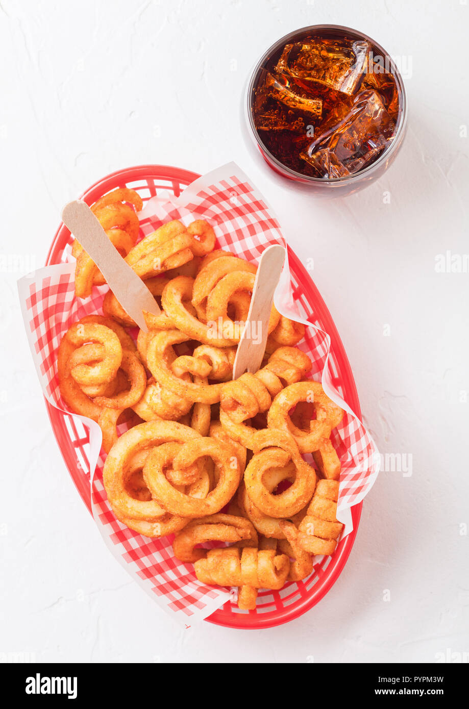 Curly fries fast food snack in red plastic tray with glass of cola on ...