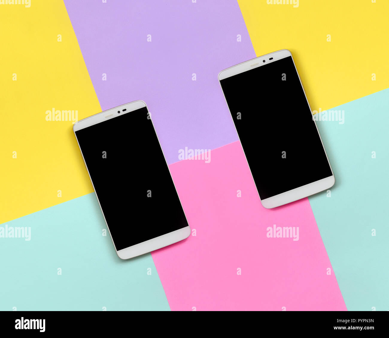 Two modern smartphones with black screens on texture background of ...