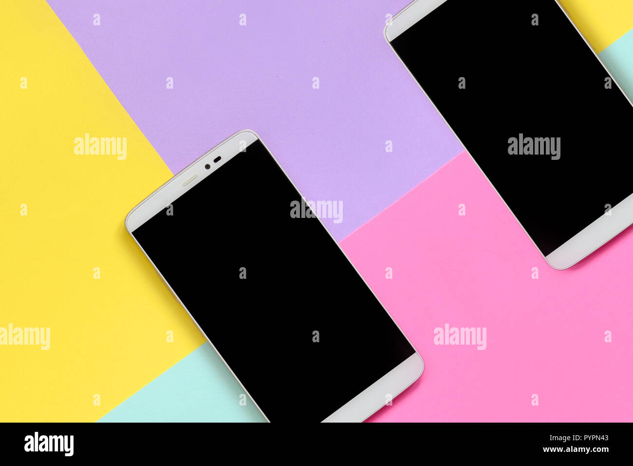 Two modern smartphones with black screens on texture background of ...