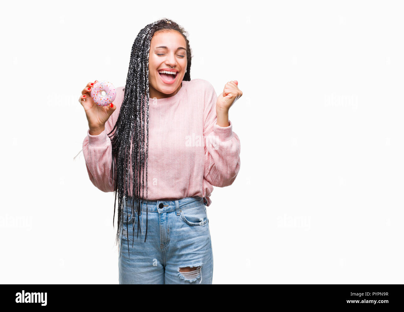 Young african american girl eating pink donut over isolated background ...