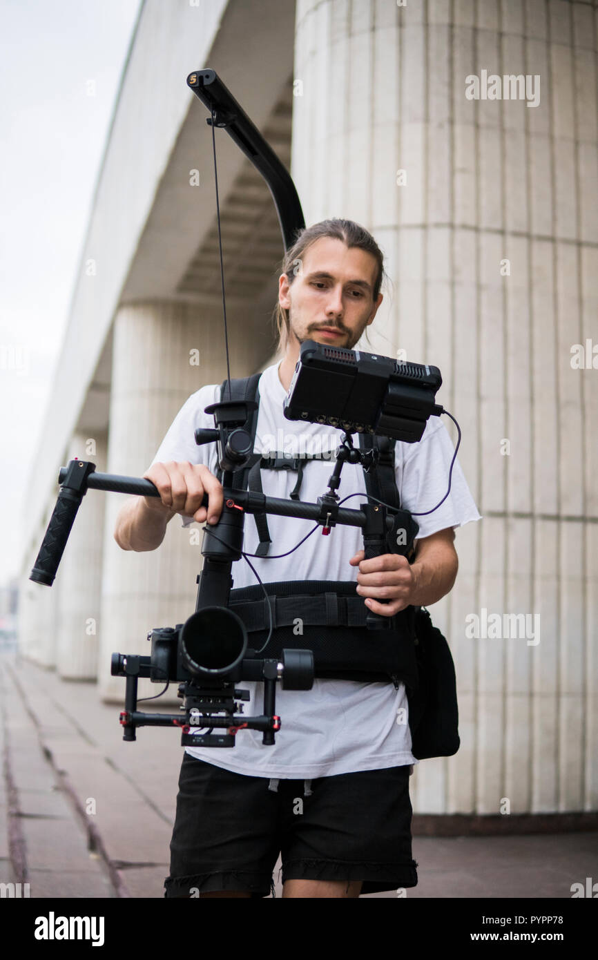 Professional videographer holding camera on 3-axis gimbal which mounted ...