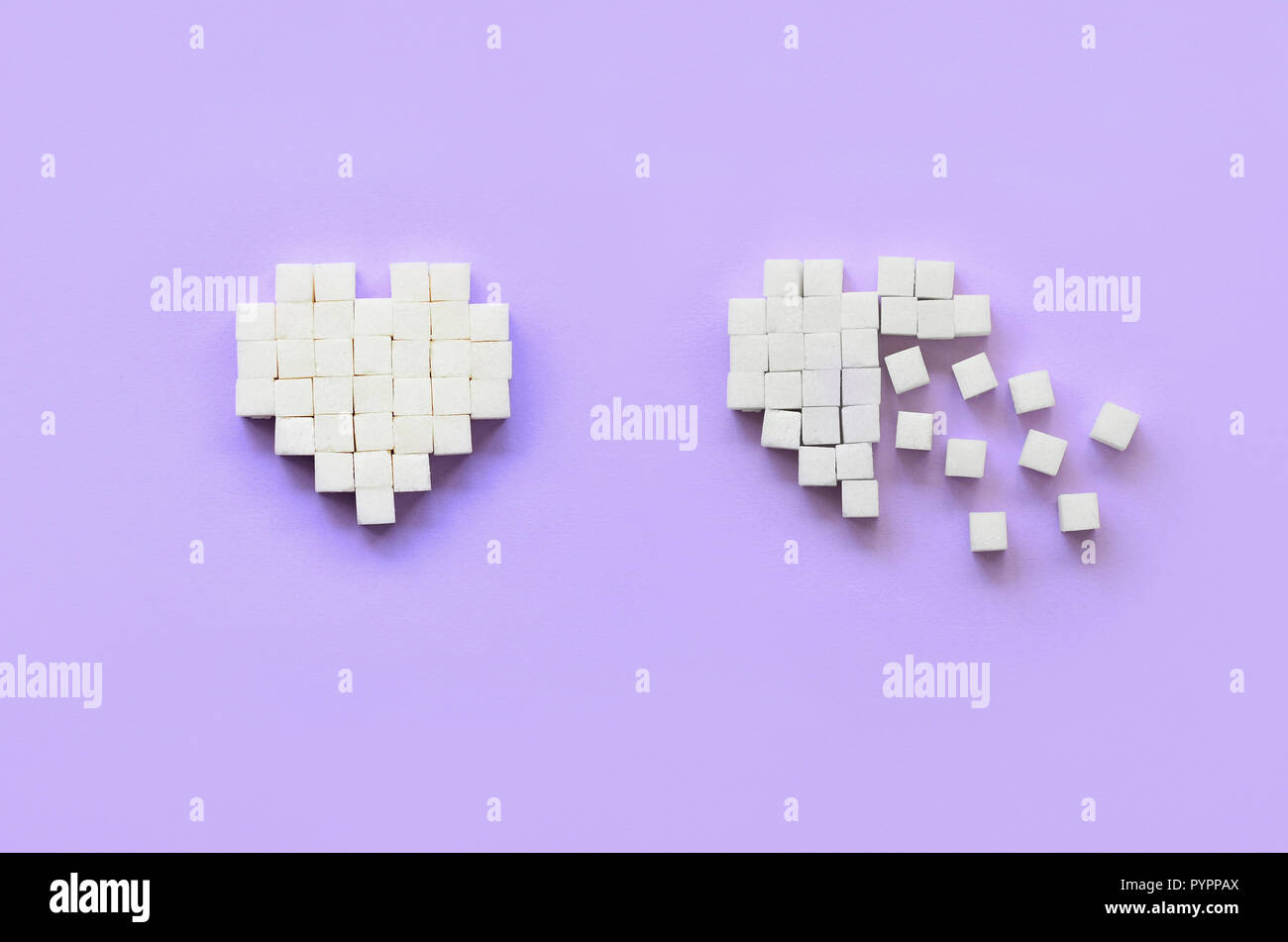A few hearts made of sugar cubes lies on a trendy pastel violet ...
