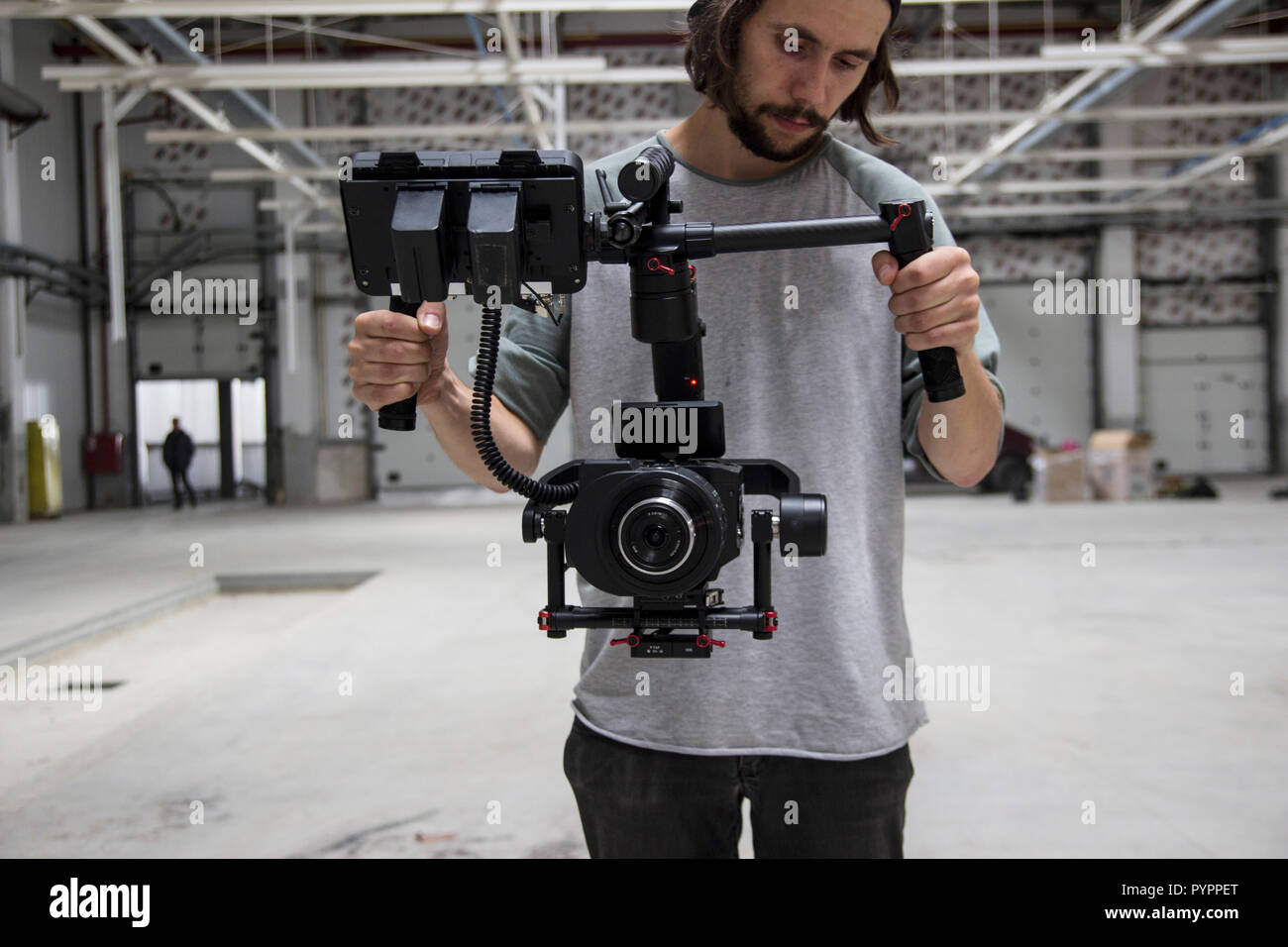 Professional videographer holding camera on 3-axis gimbal. Videographer ...