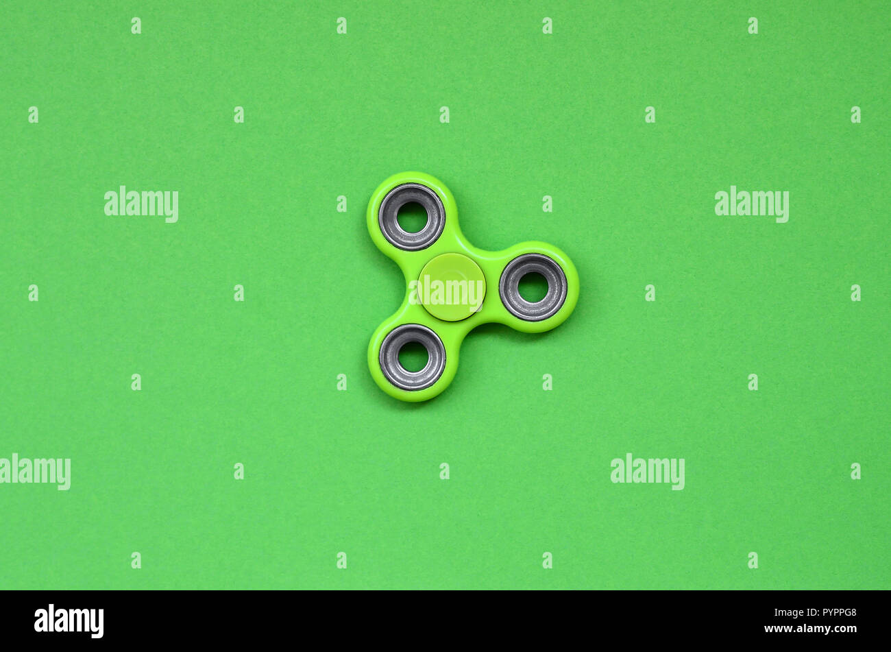 Green fidget spinner lies on texture background of fashion pastel green ...