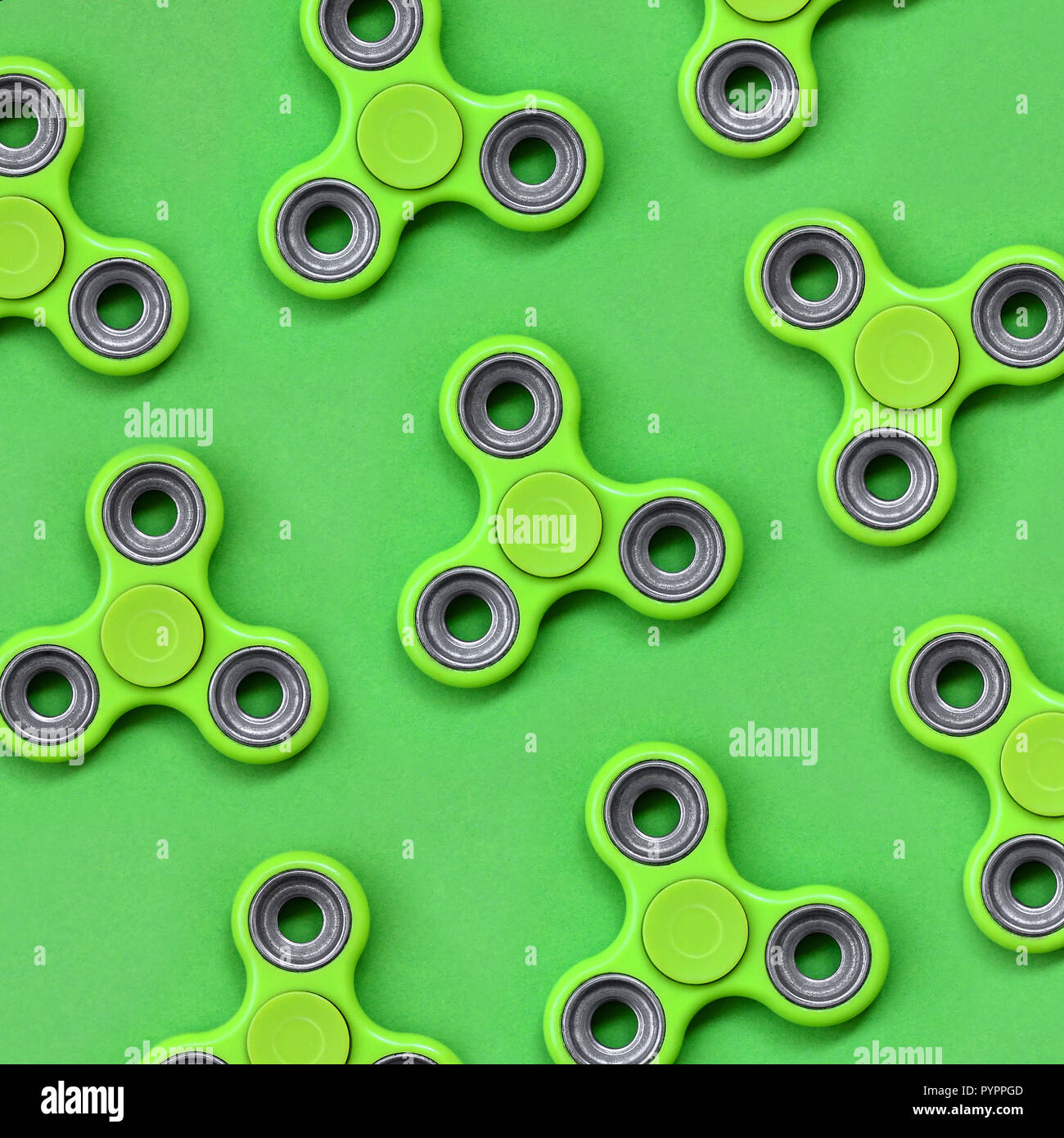 Many green fidget spinners lies on texture background of fashion pastel ...