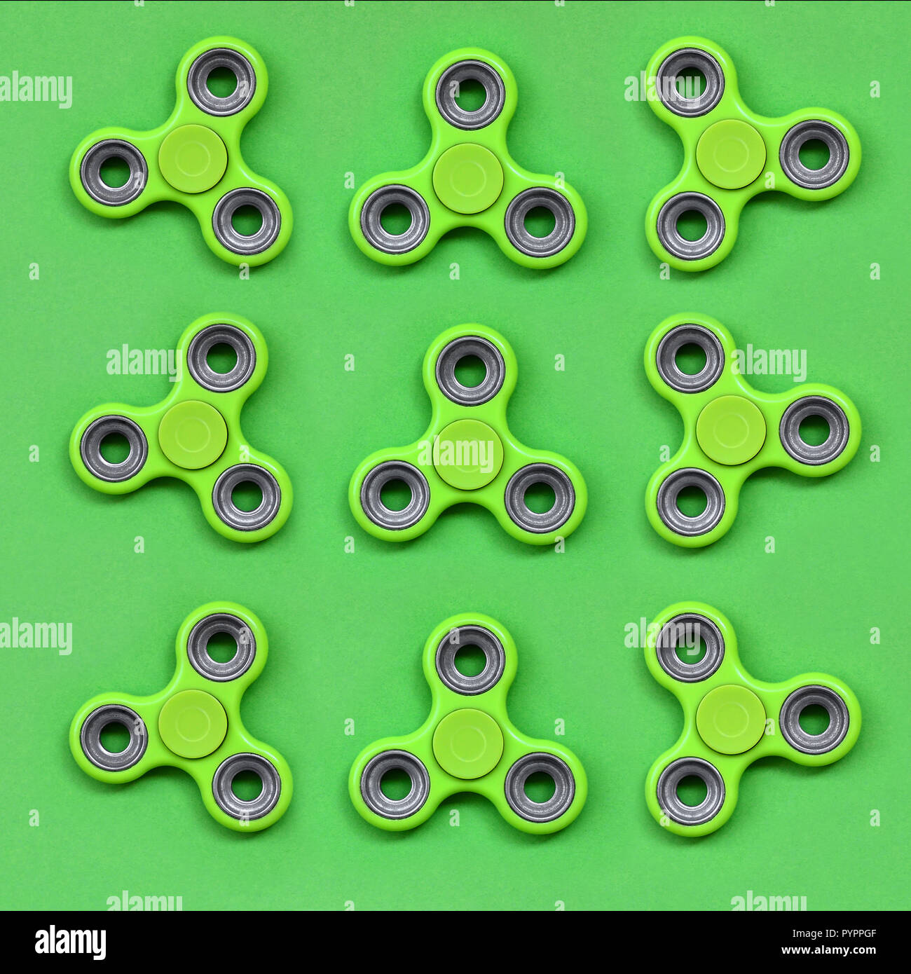 Many green fidget spinners lies on texture background of fashion pastel ...