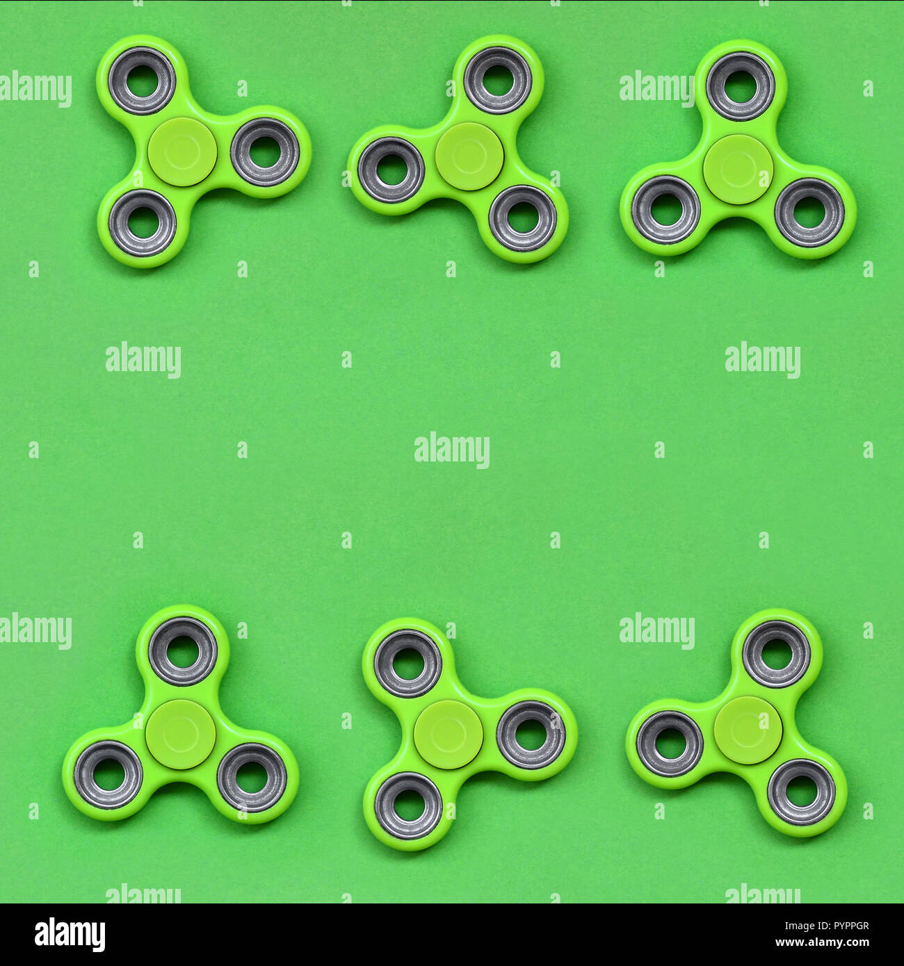 Many green fidget spinners lies on texture background of fashion pastel ...