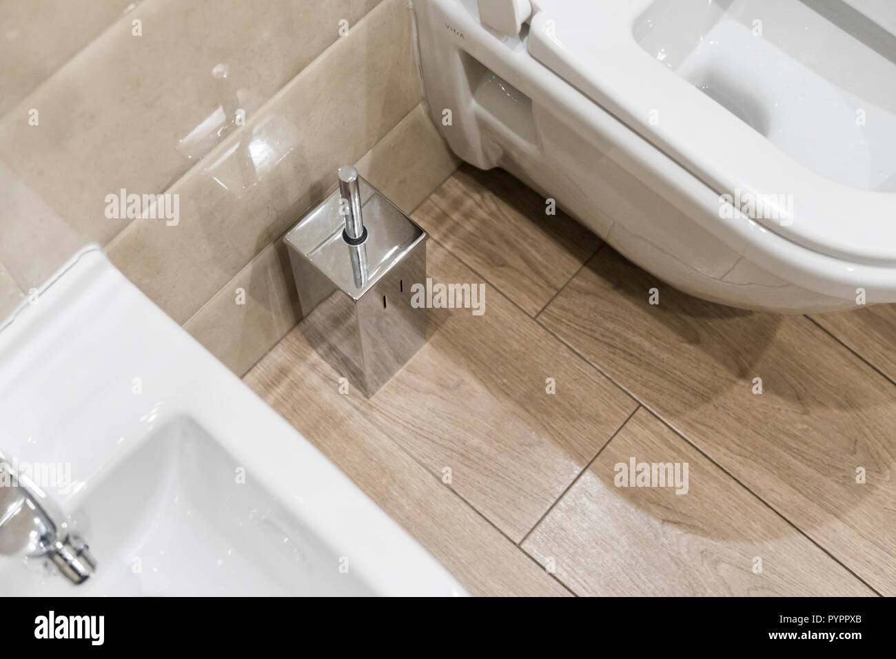 Details of white ceramic bidet and toilet with toilet brush in modern ...